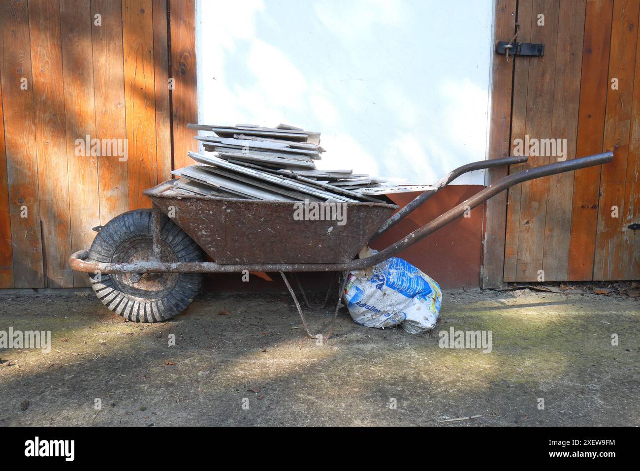Wheelbarrow filled with builder's rubble Stock Photo - Alamy