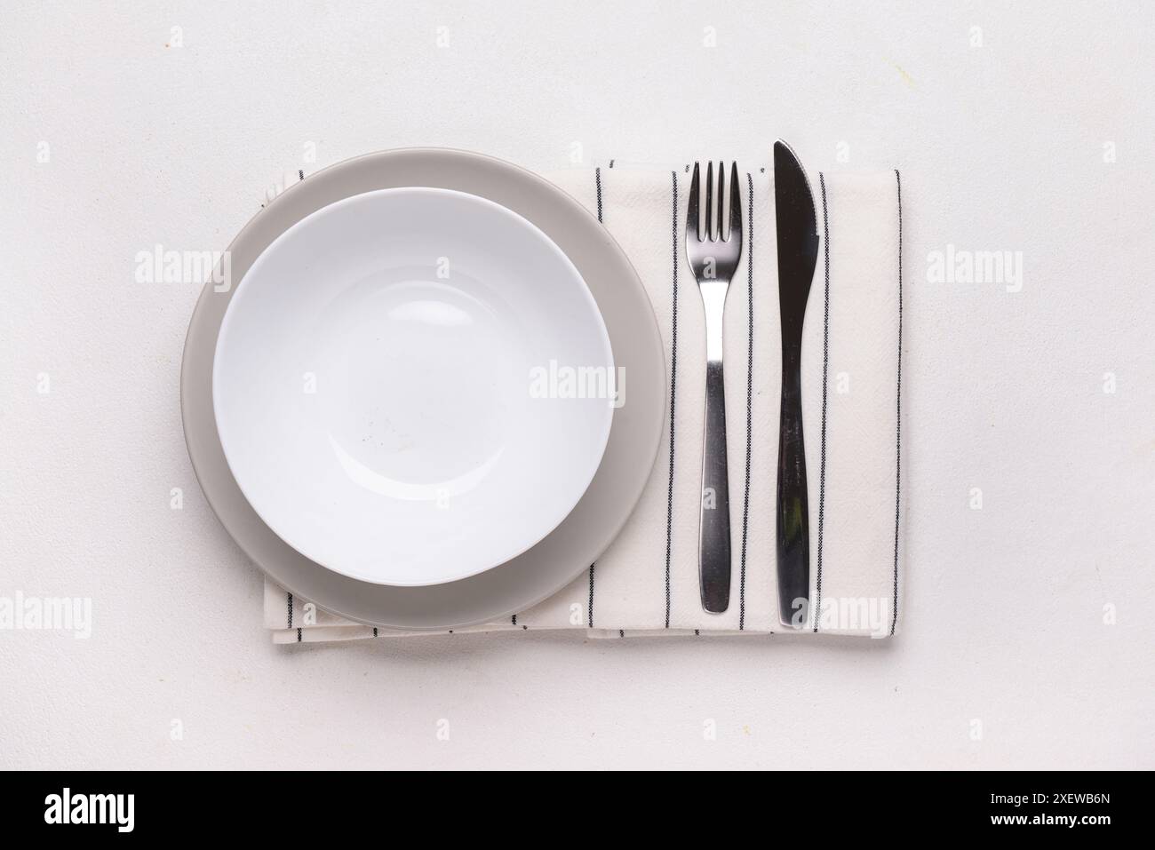 Table setting with clean plates and cutlery on white background Stock ...