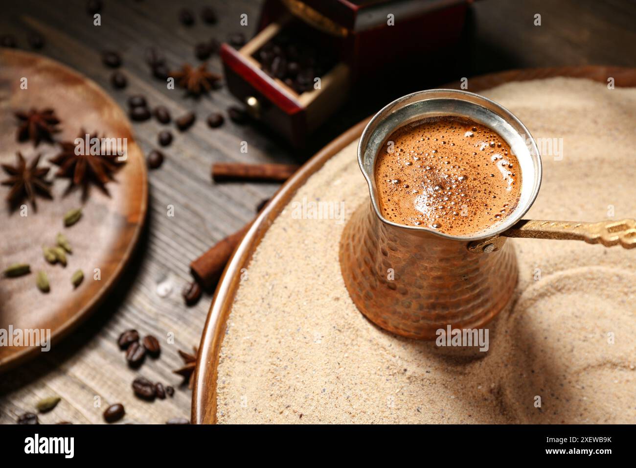 Turkish coffee cooking in sand on wooden background Stock Photo - Alamy