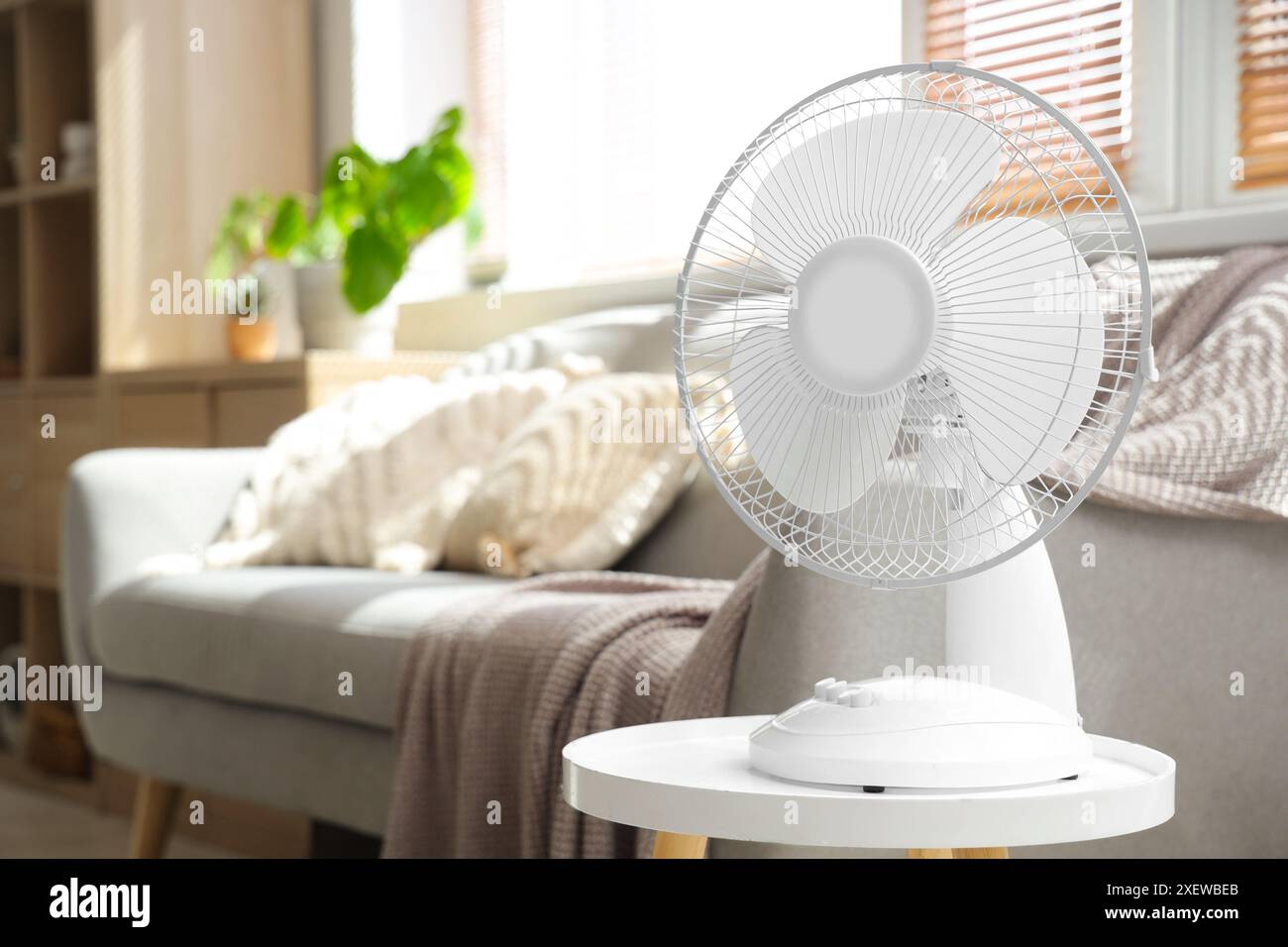 Electric fan on table in living room Stock Photo - Alamy