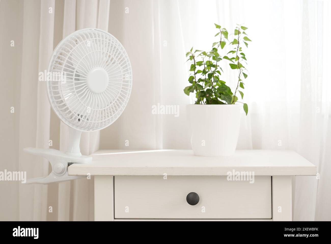 Electric fan on bedside table in bedroom Stock Photo - Alamy