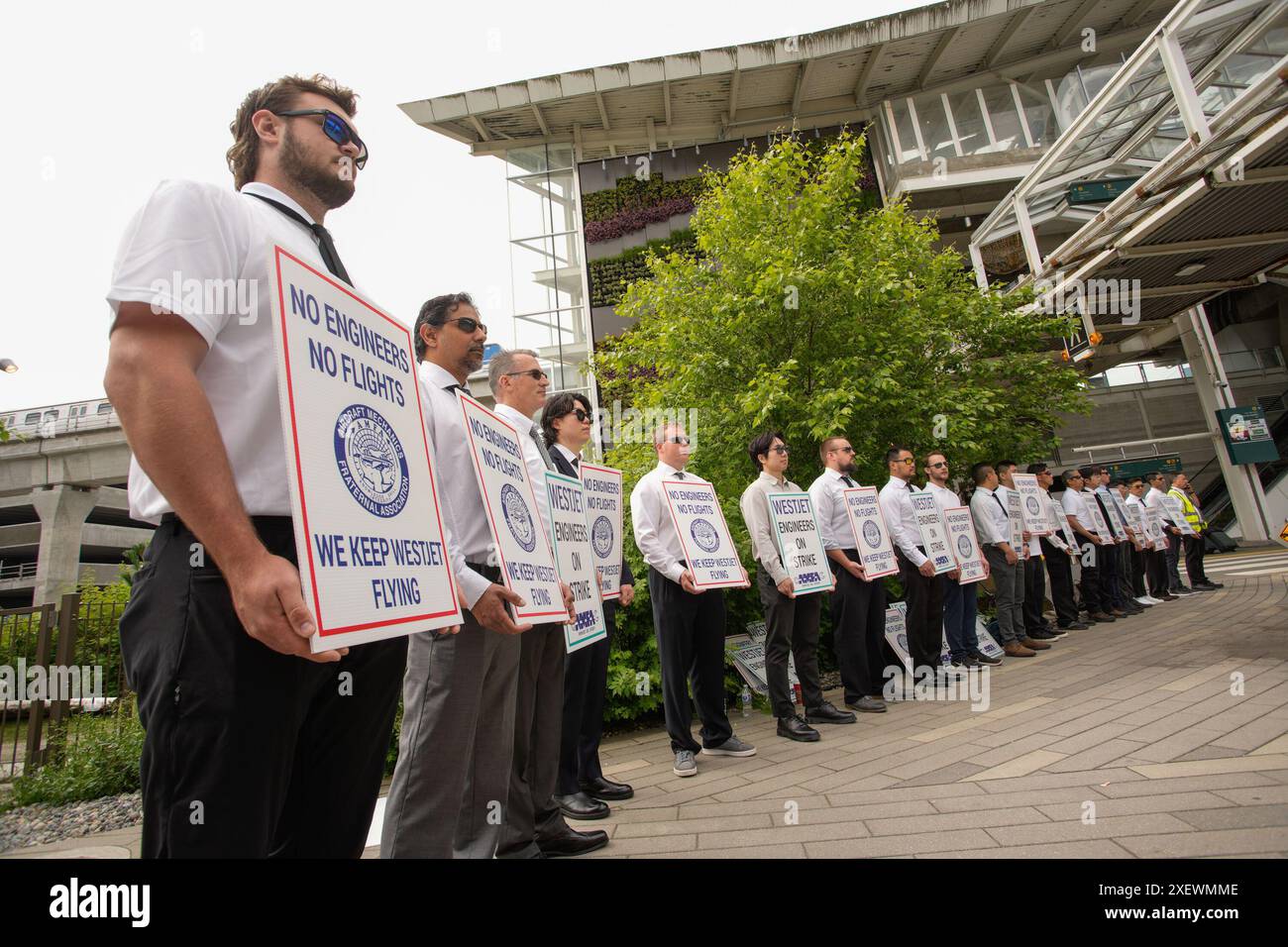 Vancouver, Canada. 29th June, 2024. WestJet airplane mechanics stand in ...