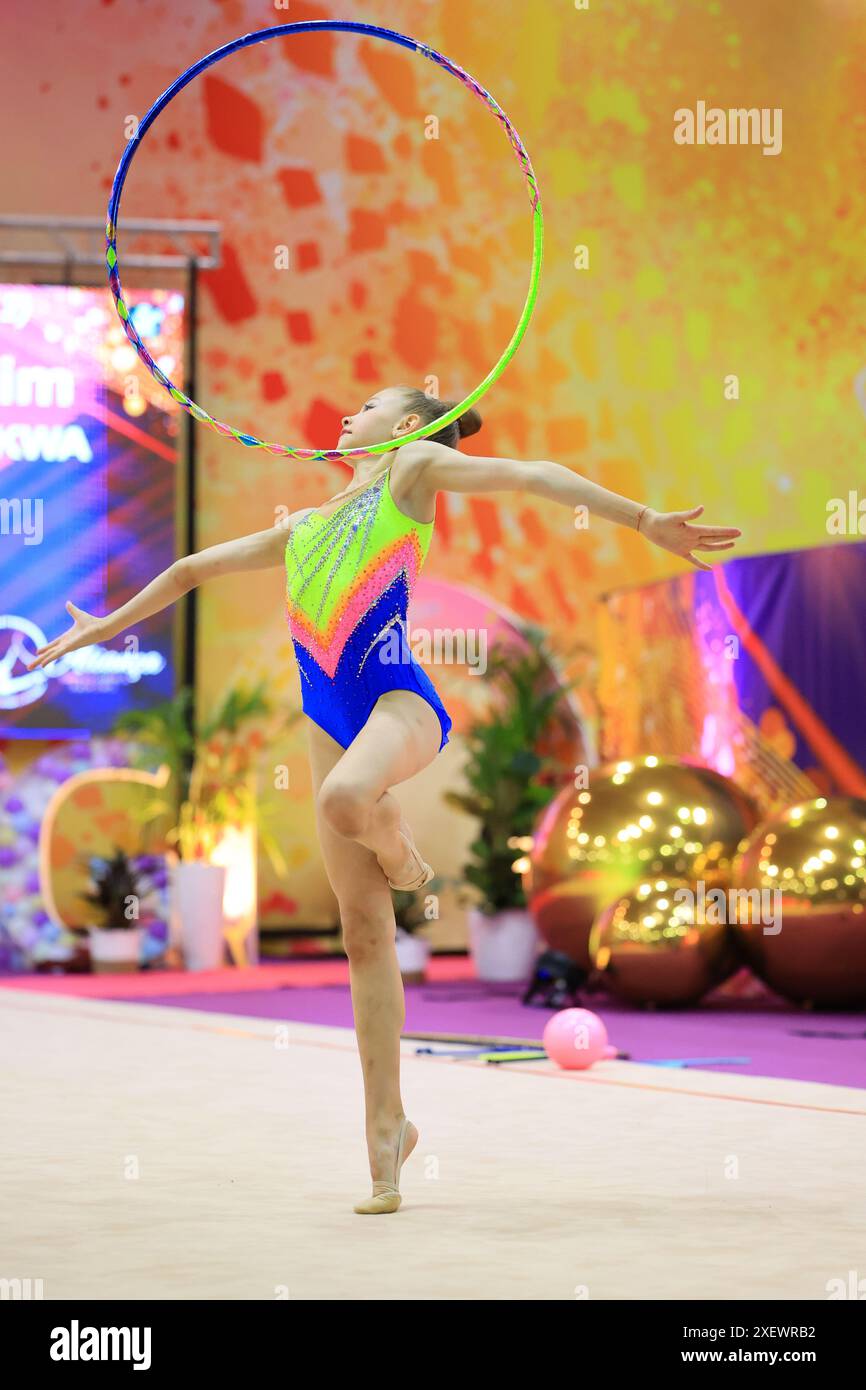 A graceful rhythmic gymnast impressively performs a hoop routine in a ...