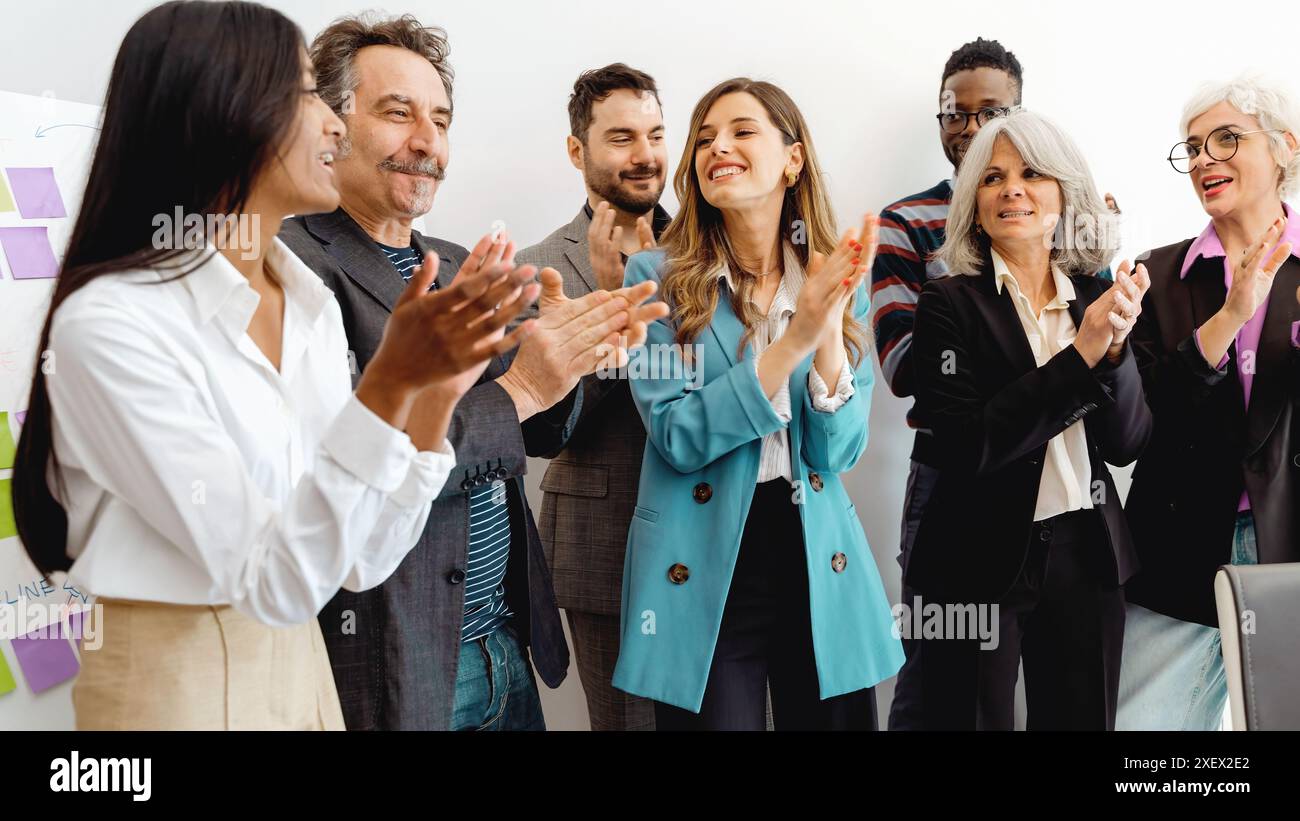 Diverse business team celebrating success in an office. Corporate team applauding and showing ...