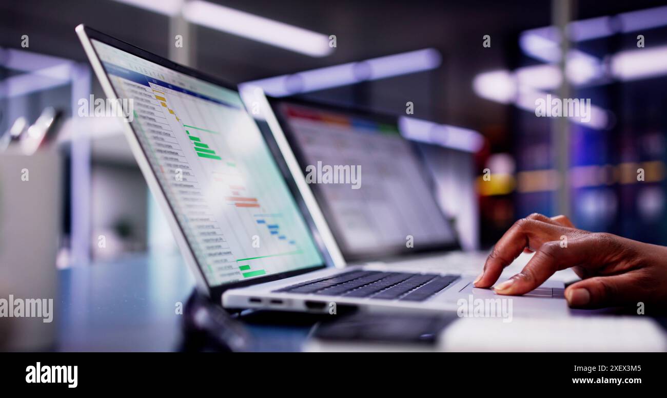 African American woman using laptop to manage multiple tasks and ...