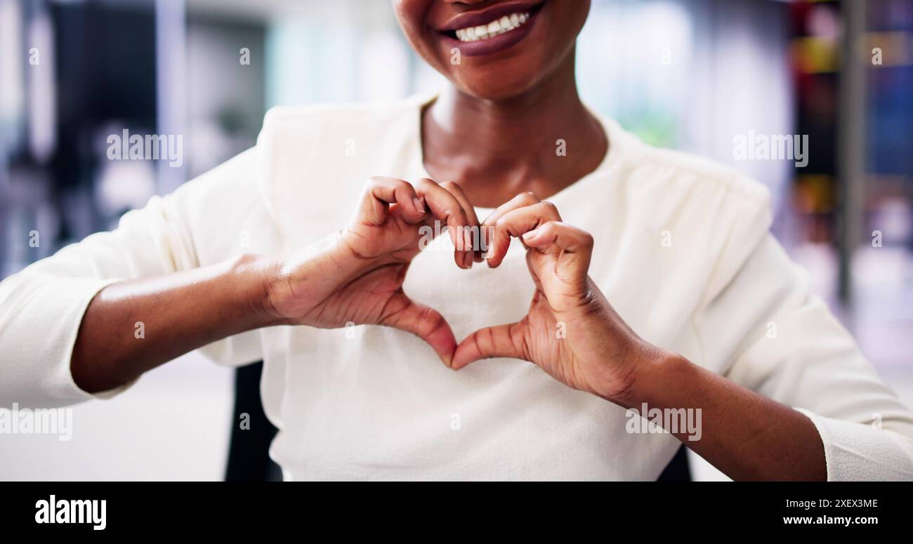Senior African American woman making heart sign with hands, symbolizing ...