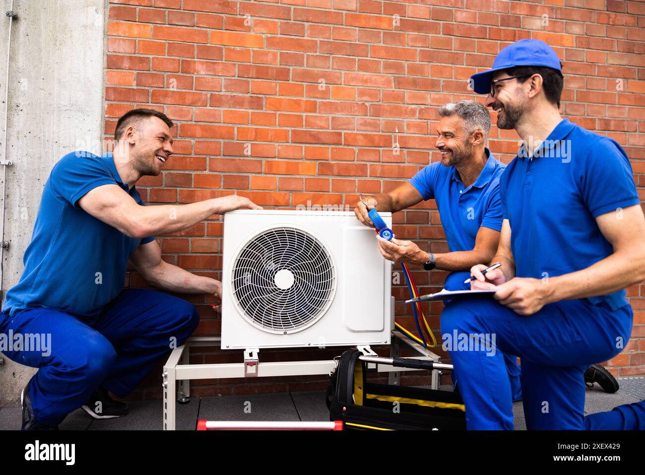 Skilled HVAC technician installing air conditioner unit for commercial building, conducting ...