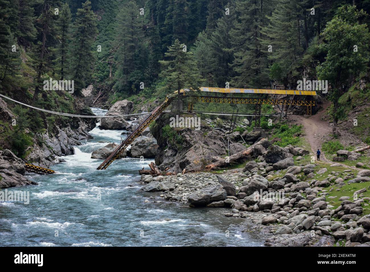 Kulgam, India. 29th June, 2024. A visitor walks near the damaged bridge ...