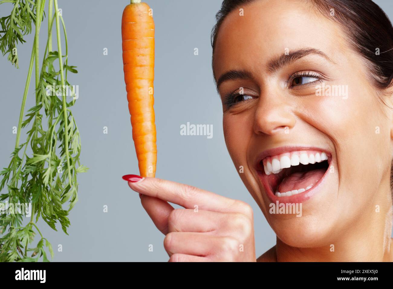 Woman, laughing and skincare with carrot in studio background and ...
