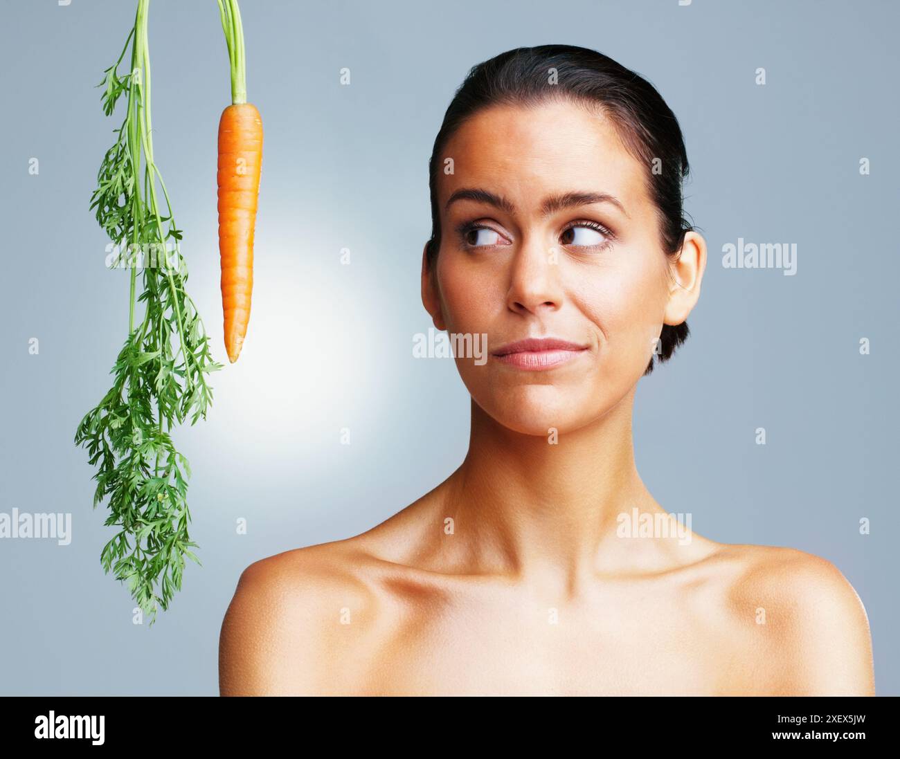 Woman, thinking and skincare with carrot in studio background with unsure for option and ...
