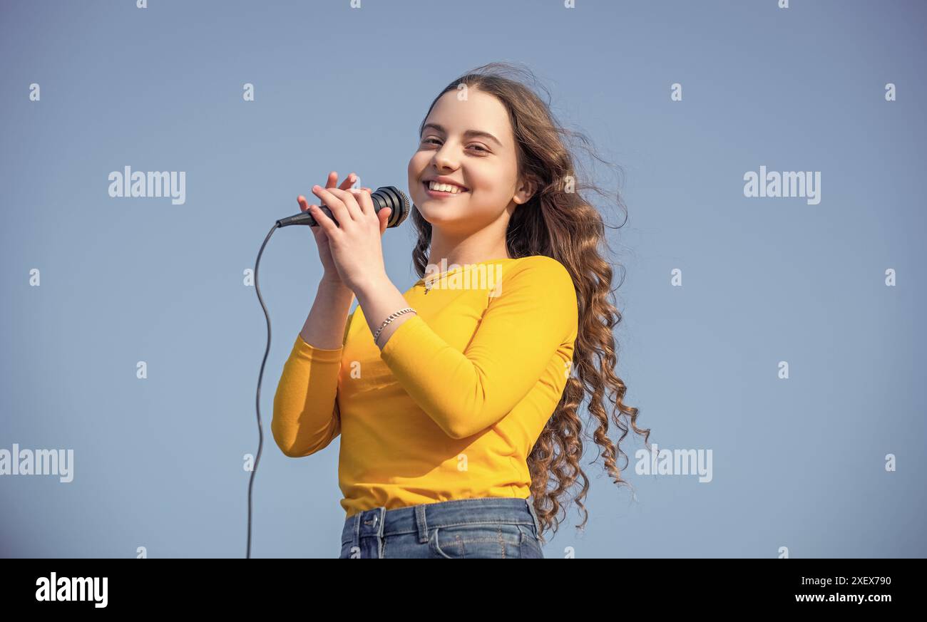 happy teen girl singing song in microphone Stock Photo - Alamy
