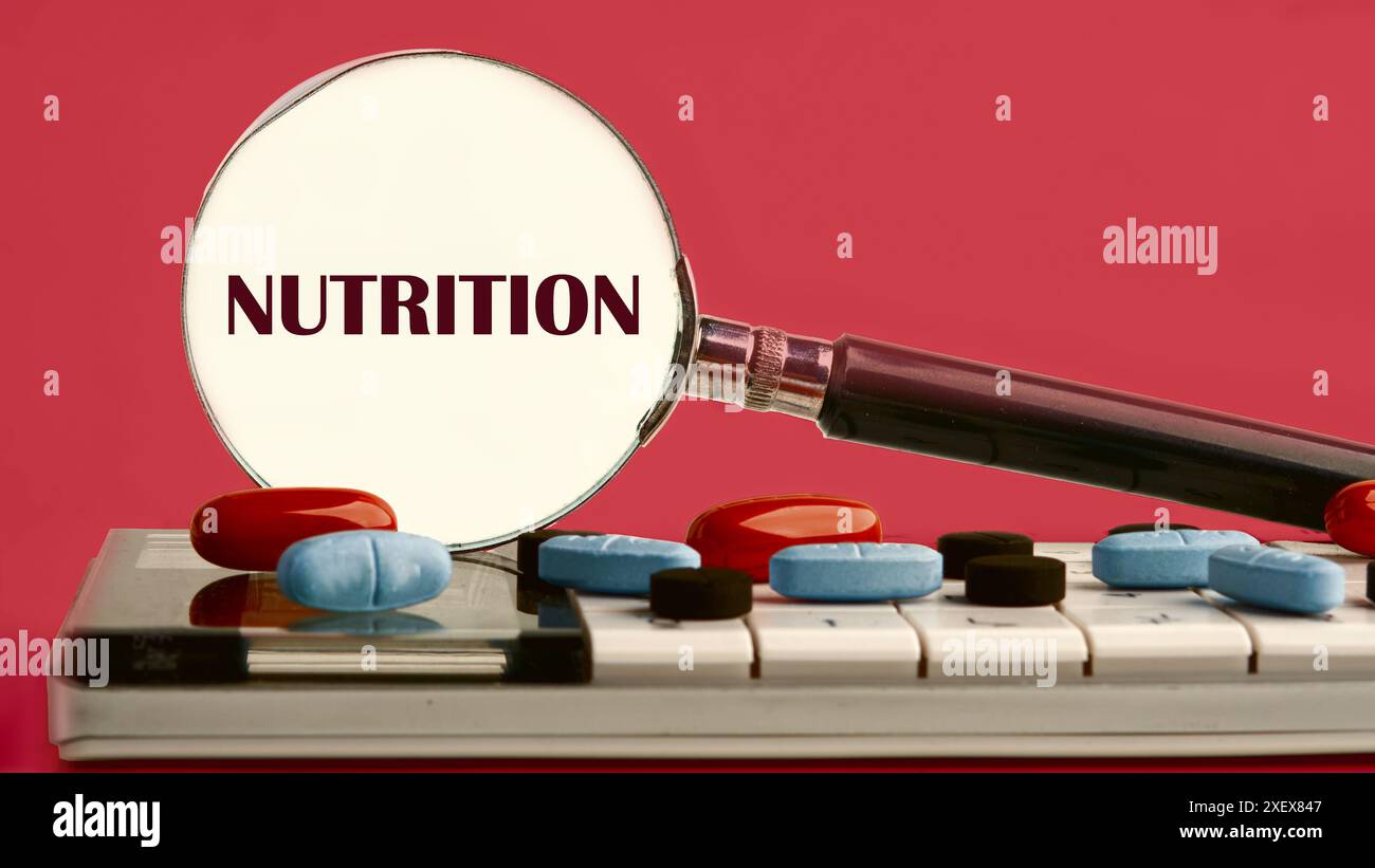 NUTRITION word written through a magnifying glass on a calculator with ...