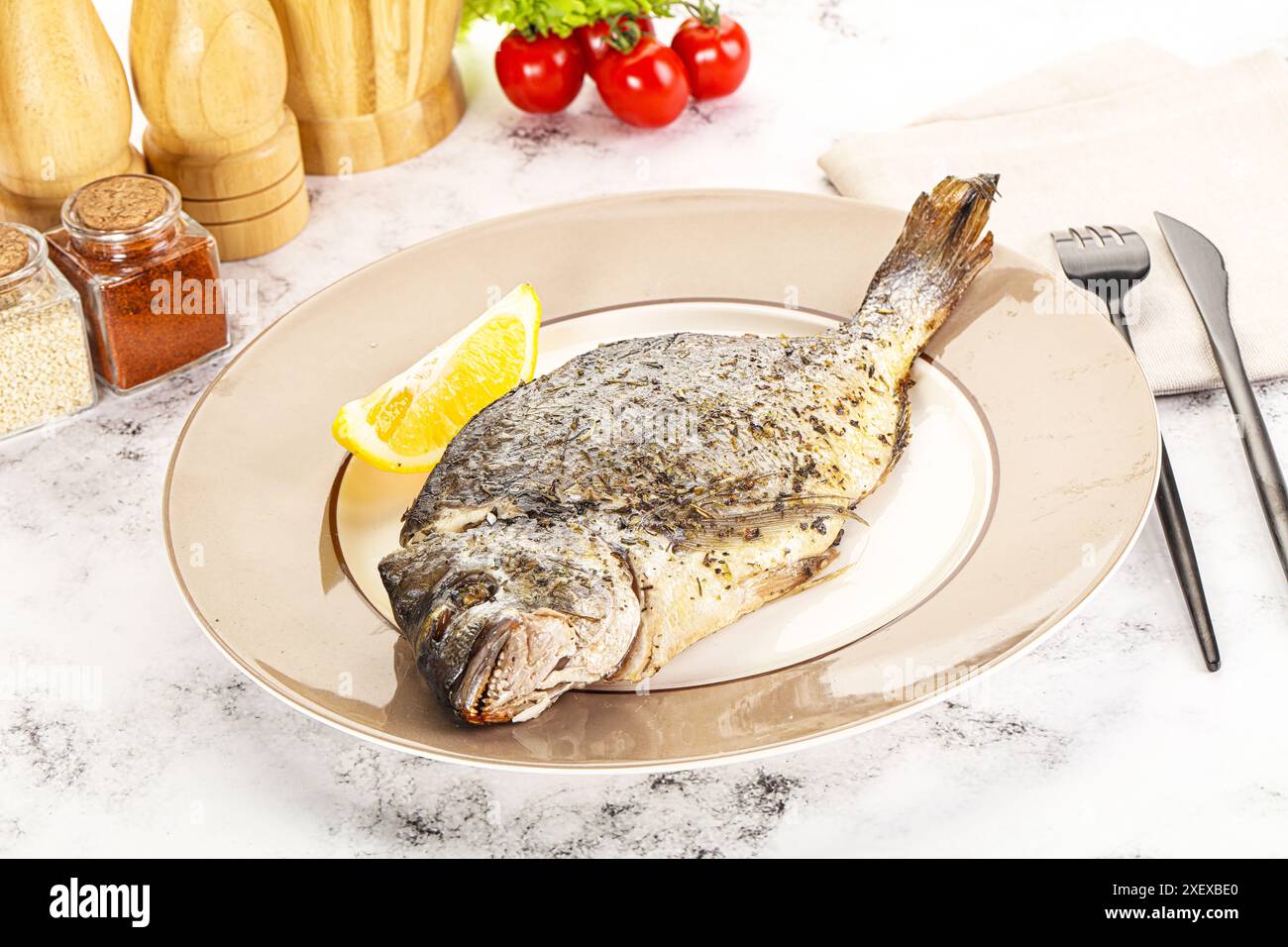 Baked Dorado fish served lemon slice Stock Photo - Alamy