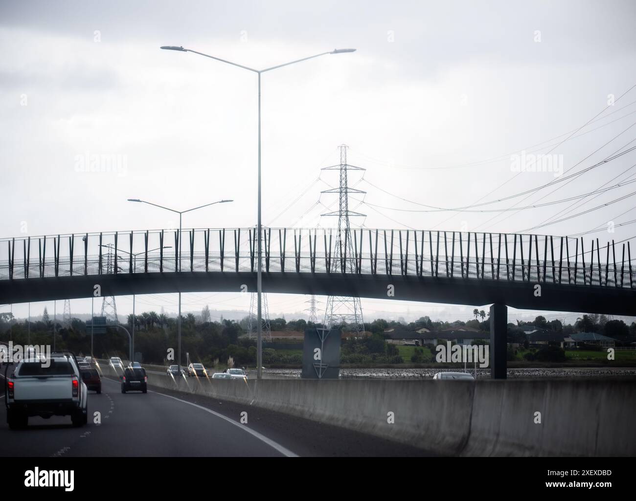 Transmission pylons and power lines along the motorway. Bridge across ...