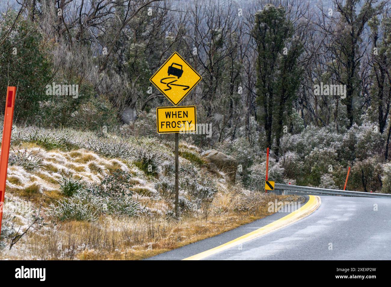 Caution Yellow road sign indicating Slippery when Frosty against a snow ...