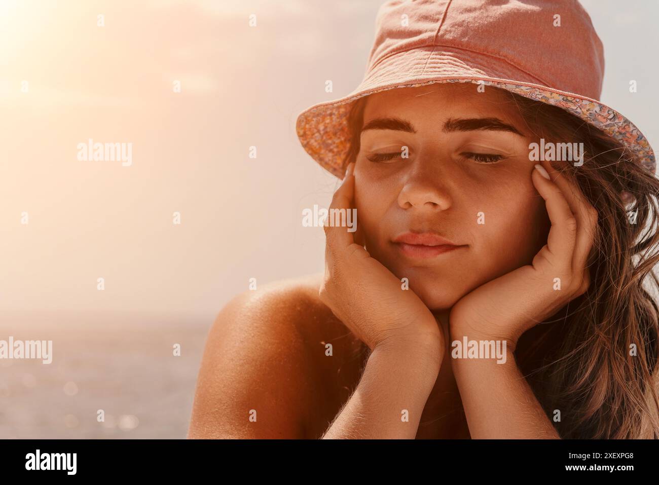 Happy young woman sunbathing or tanning on a seaside beach during ...