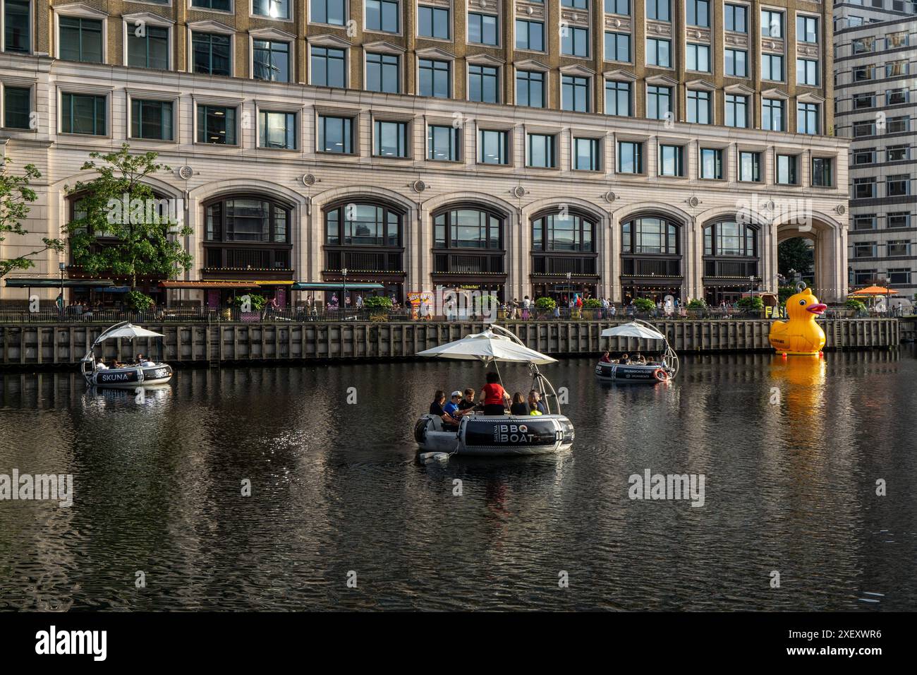 People on floating tubes having a bbq , Canary Wharf ,London,England,UK ...