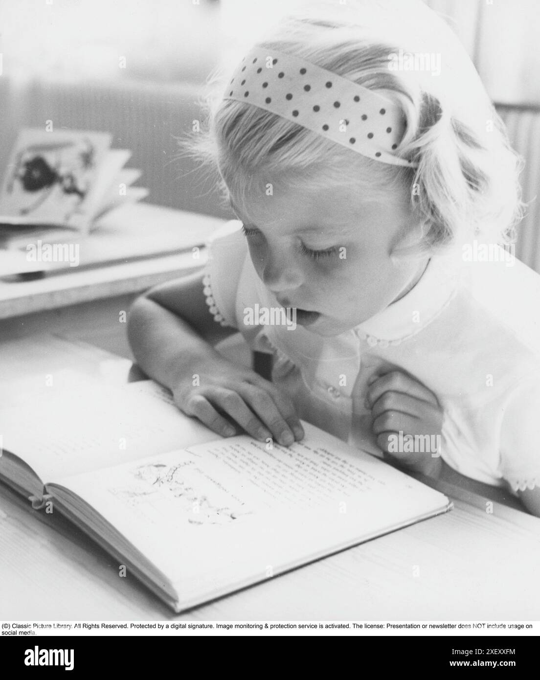 School in the 1950s. A girl is seen sitting at her desk in the ...