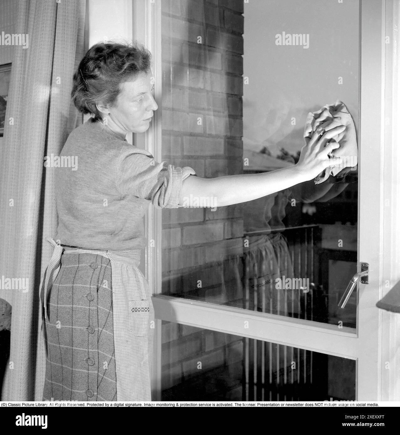 Windowcleaning in the 1950s. A woman is seen cleaning the windows of ...