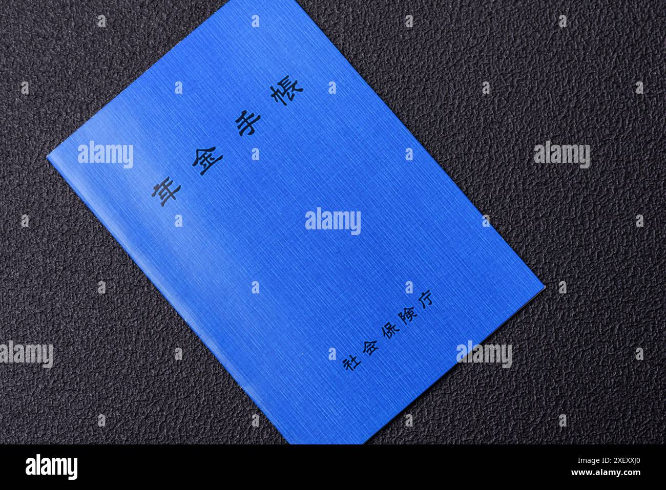 Pension book or Japanese citizen ID card on dark concrete background ...