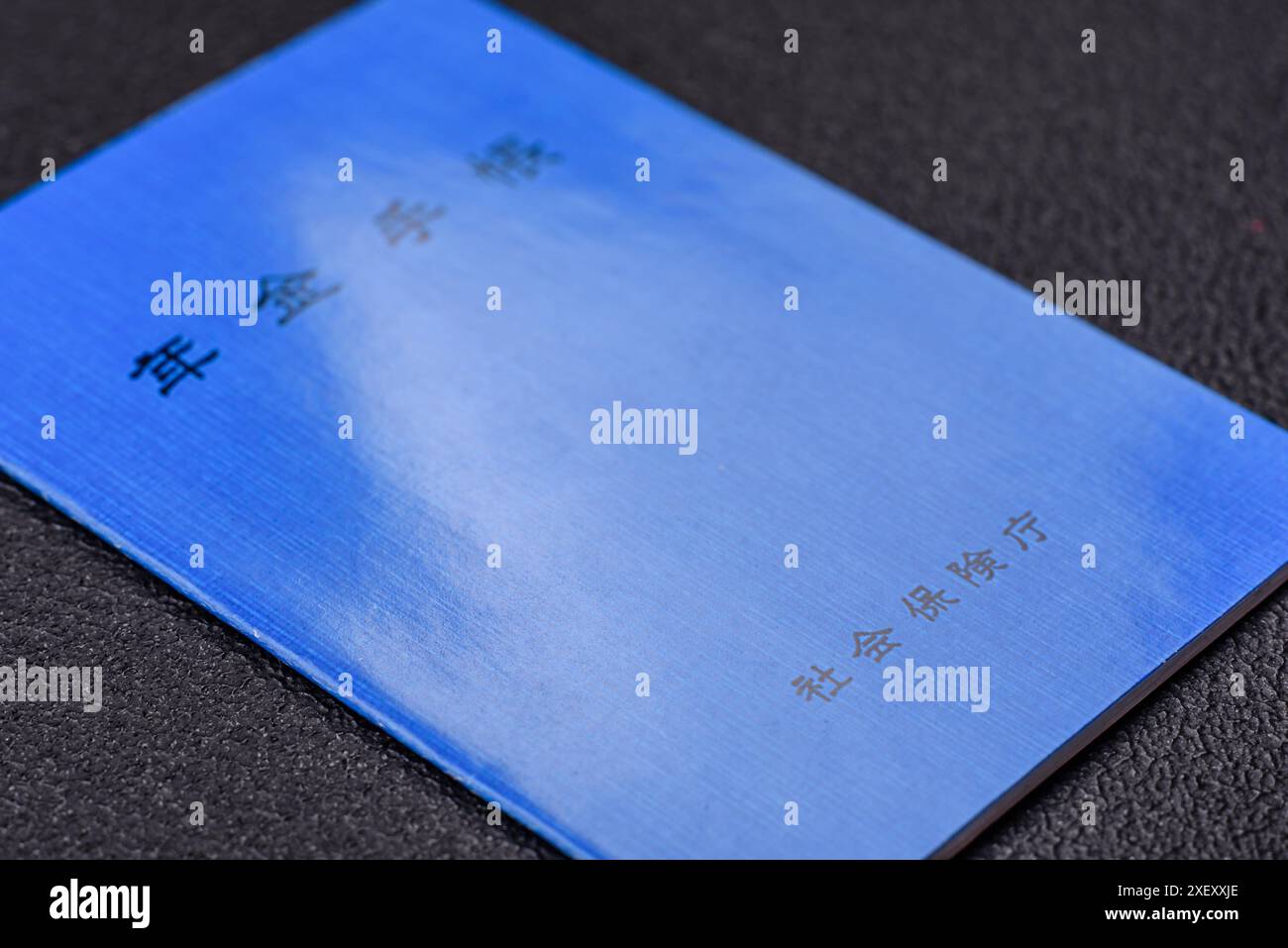 Pension book or Japanese citizen ID card on dark concrete background ...