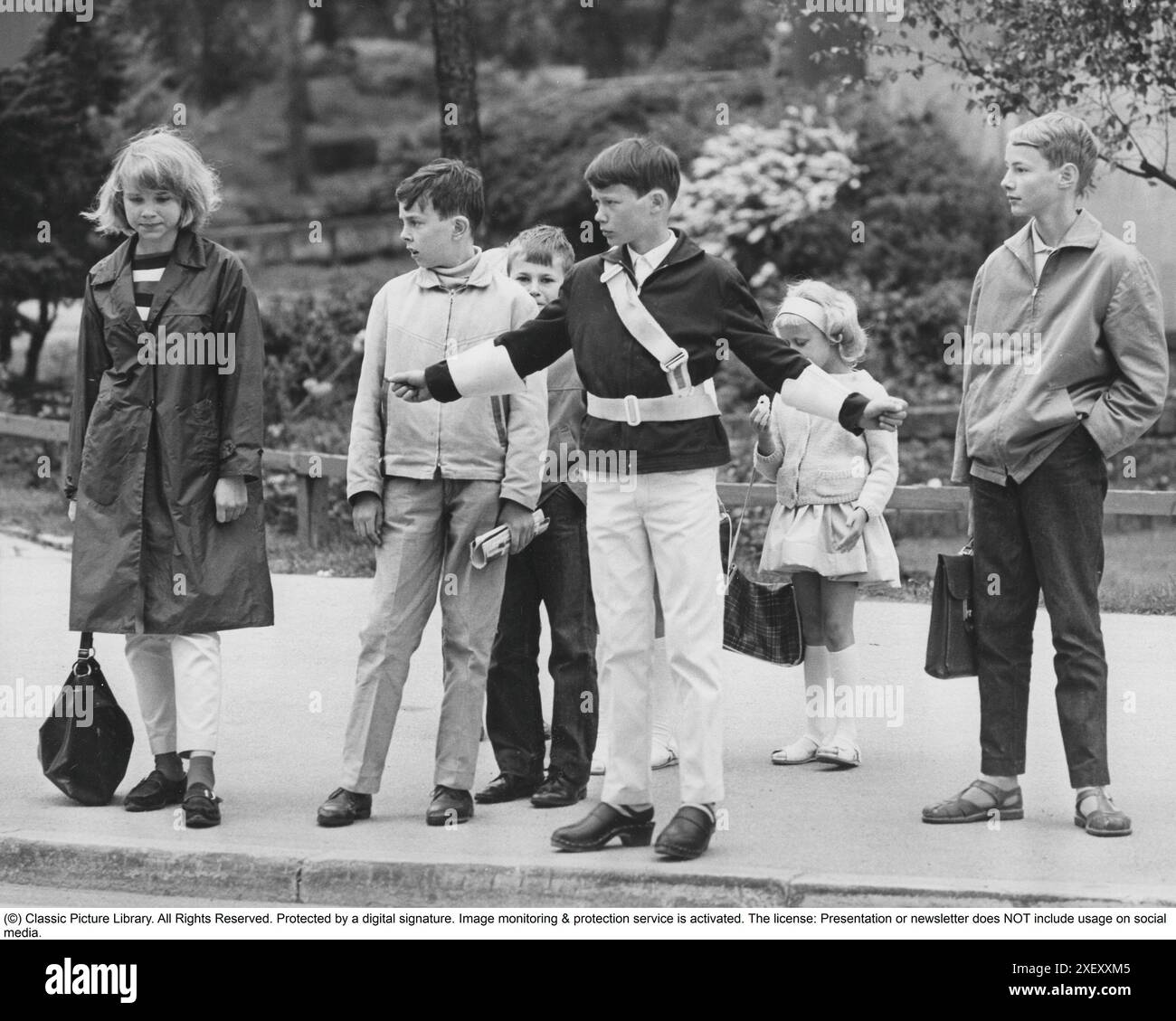 Junior safety patrol in the 1960s. A teenage boy stands with his arms ...