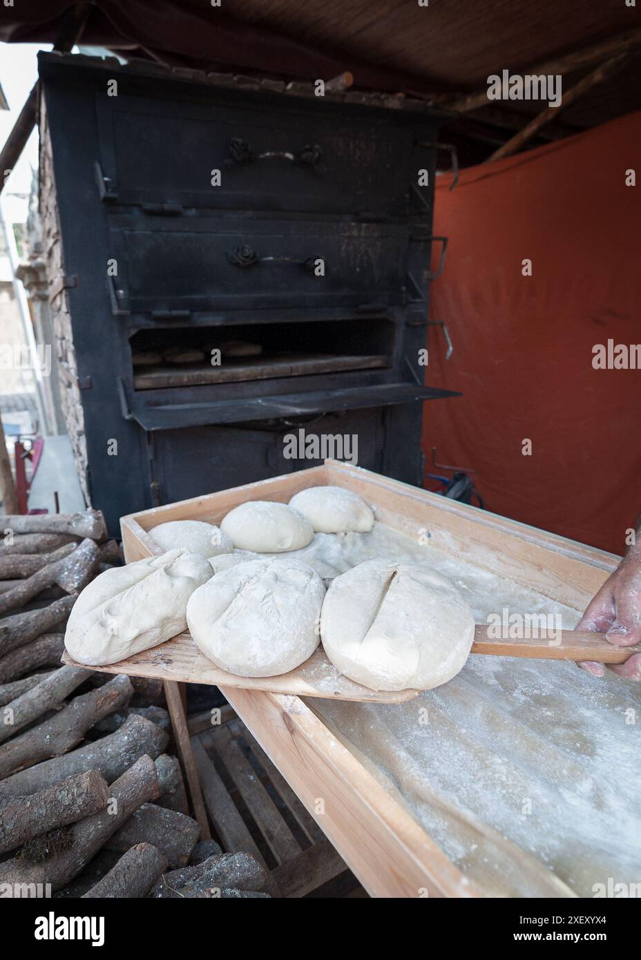 introducing mass baker of bread in wood stove Stock Photo - Alamy