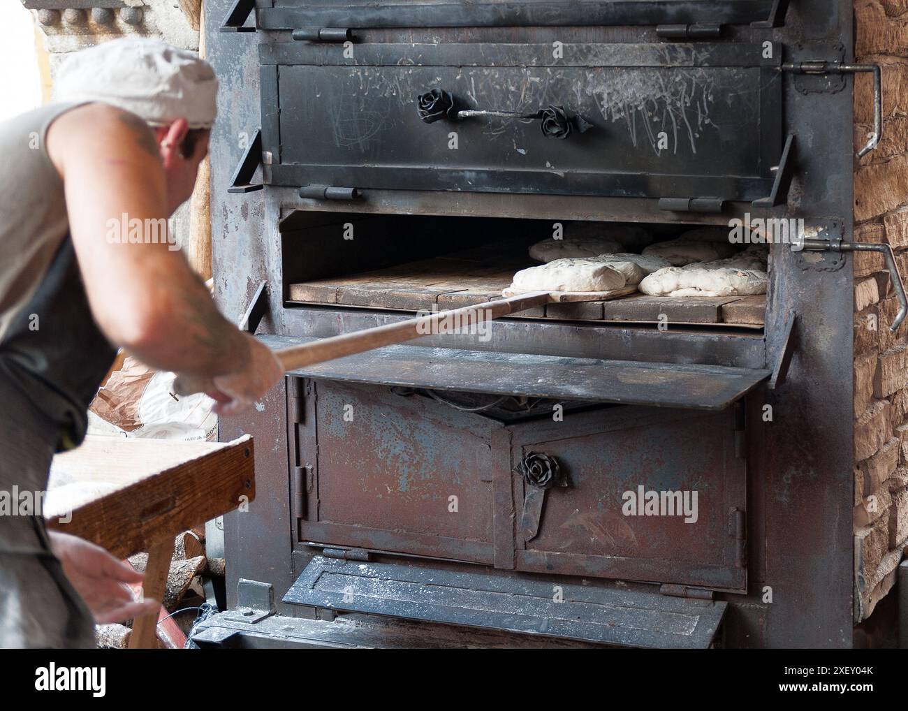 introducing mass baker of bread in wood stove Stock Photo - Alamy