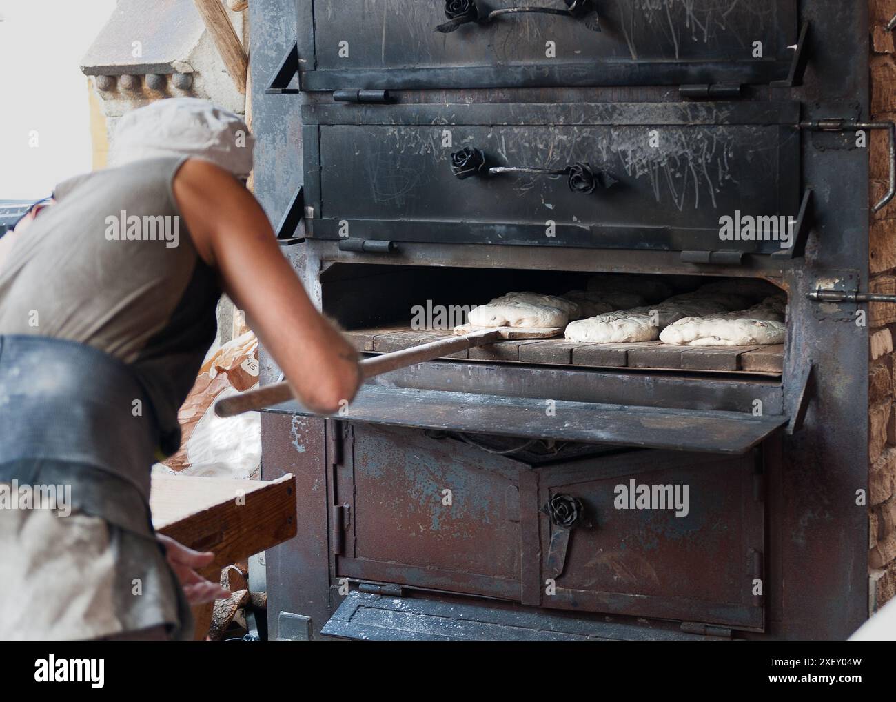 introducing mass baker of bread in wood stove Stock Photo - Alamy