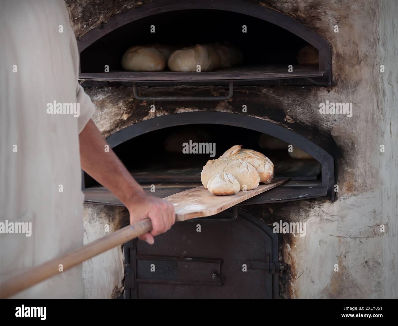 introducing mass baker of bread in wood stove Stock Photo - Alamy