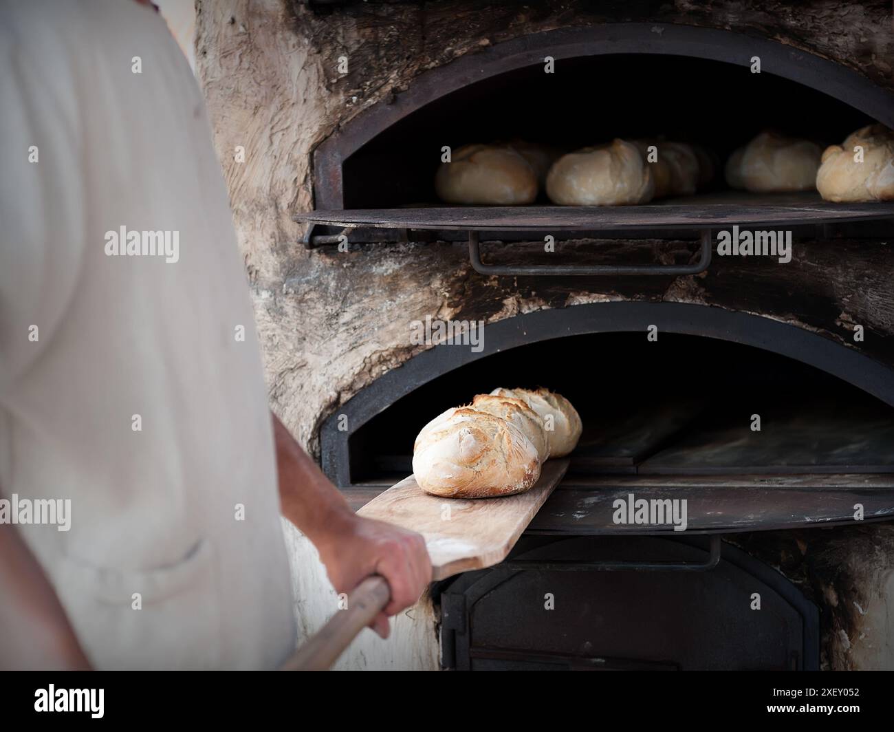 introducing mass baker of bread in wood stove Stock Photo - Alamy