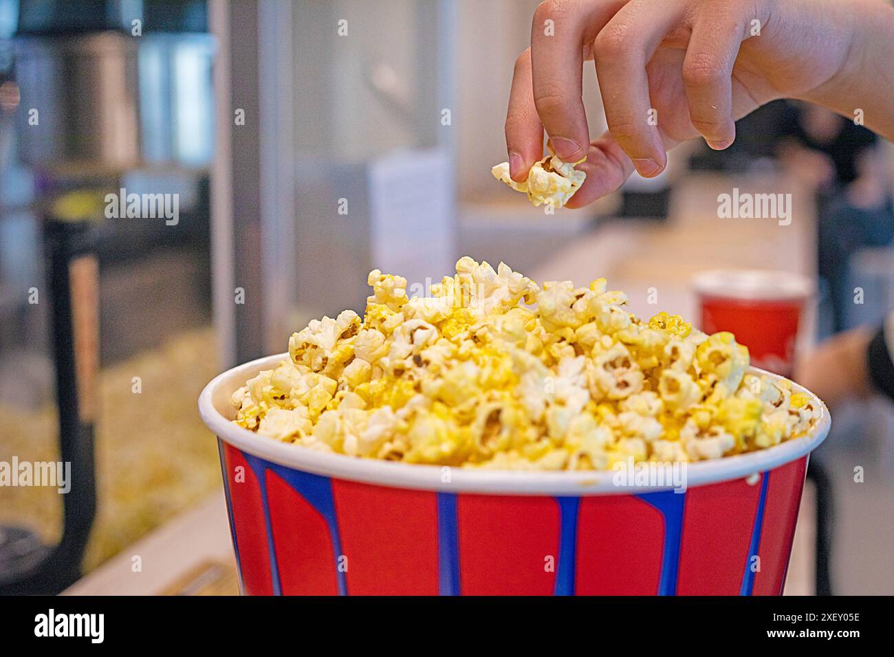 child tastes classic popcorn before watching a movie. Family day out ...