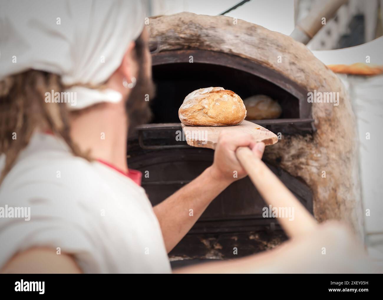 introducing mass baker of bread in wood stove Stock Photo - Alamy