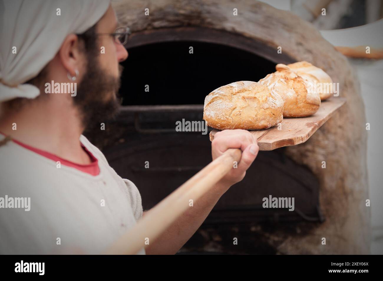 introducing mass baker of bread in wood stove Stock Photo - Alamy