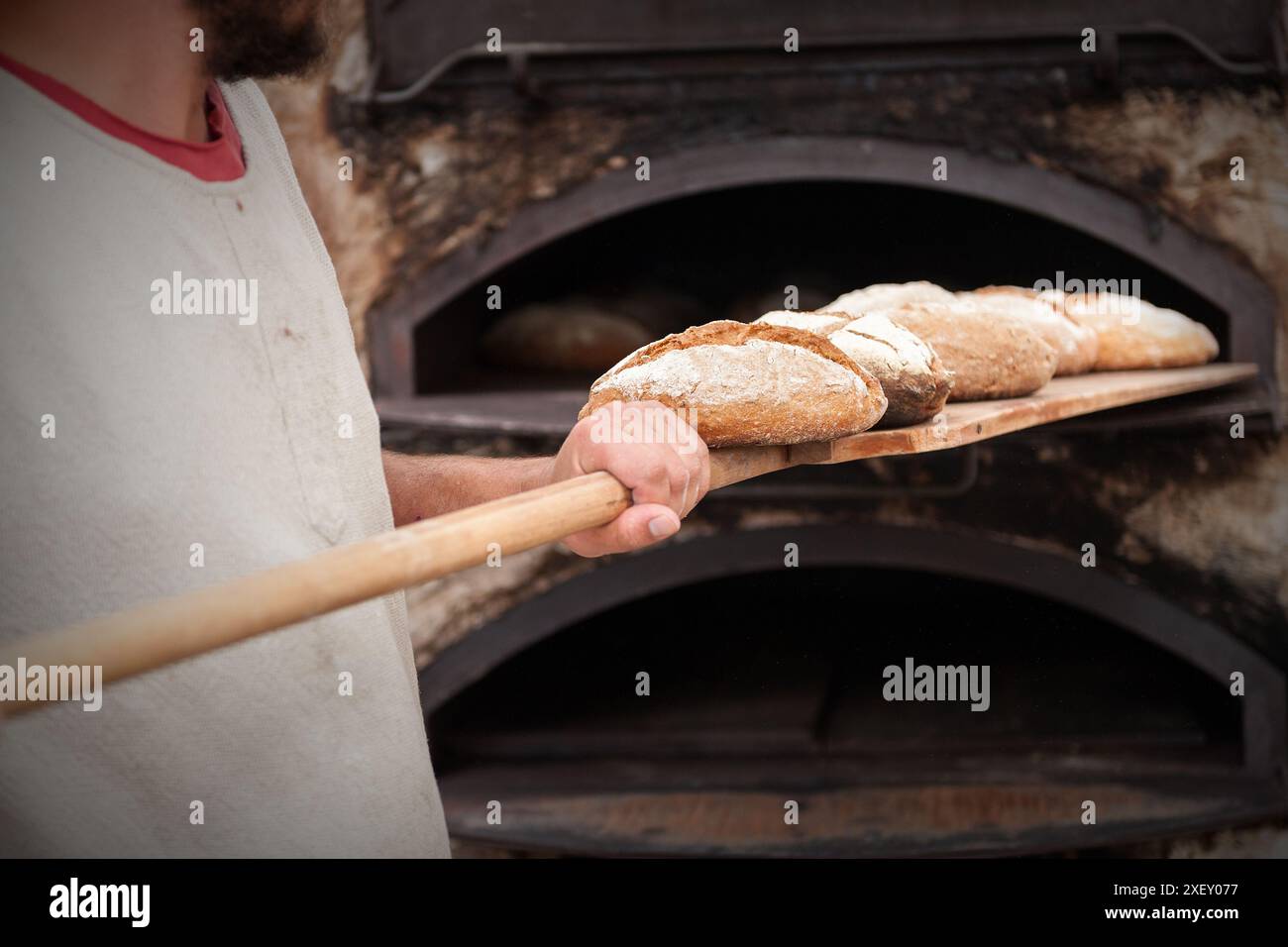 introducing mass baker of bread in wood stove Stock Photo - Alamy