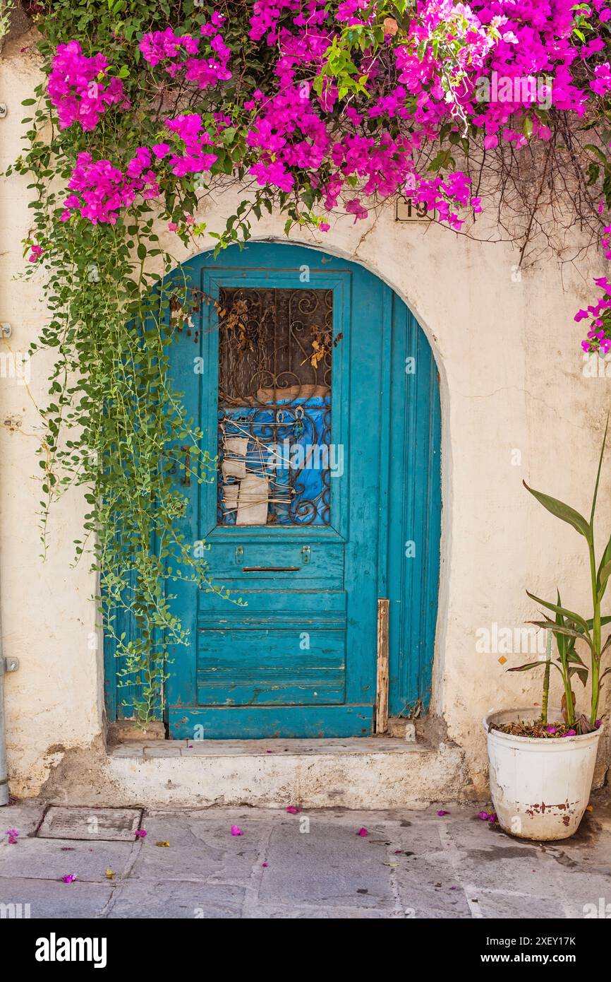 Facade of old traditional Greek building with beautiful pink flowers ...