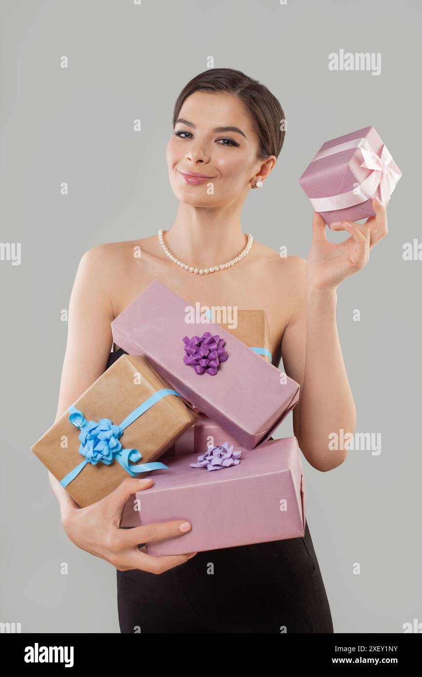 Happy excited young woman holding present gift box posing against white ...