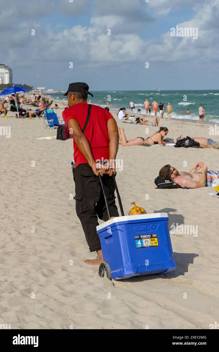 Miami, Florida, USA - 5 December 2023: Trader pulling a cool box of ... Miami, Florida, USA - 5 December 2023: Trader pulling a cool box of ...