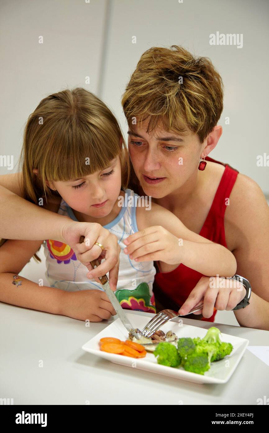 Mother and daughter eating vegetables, tasting session in sensory ...