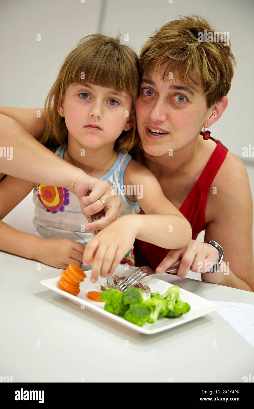 Mother and daughter eating vegetables, tasting session in sensory ...