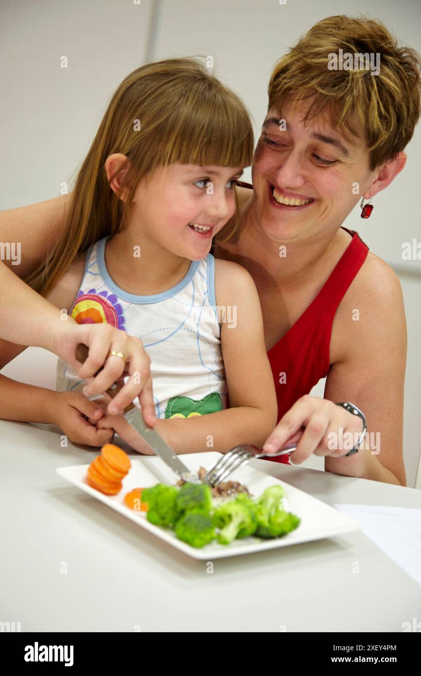 Mother and daughter eating vegetables, tasting session in sensory ...