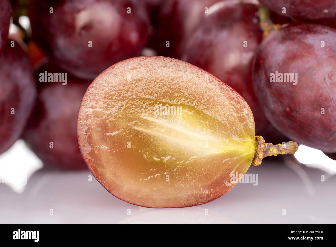 One half of a berry and one bunch of grapes, macro, isolated on white ...