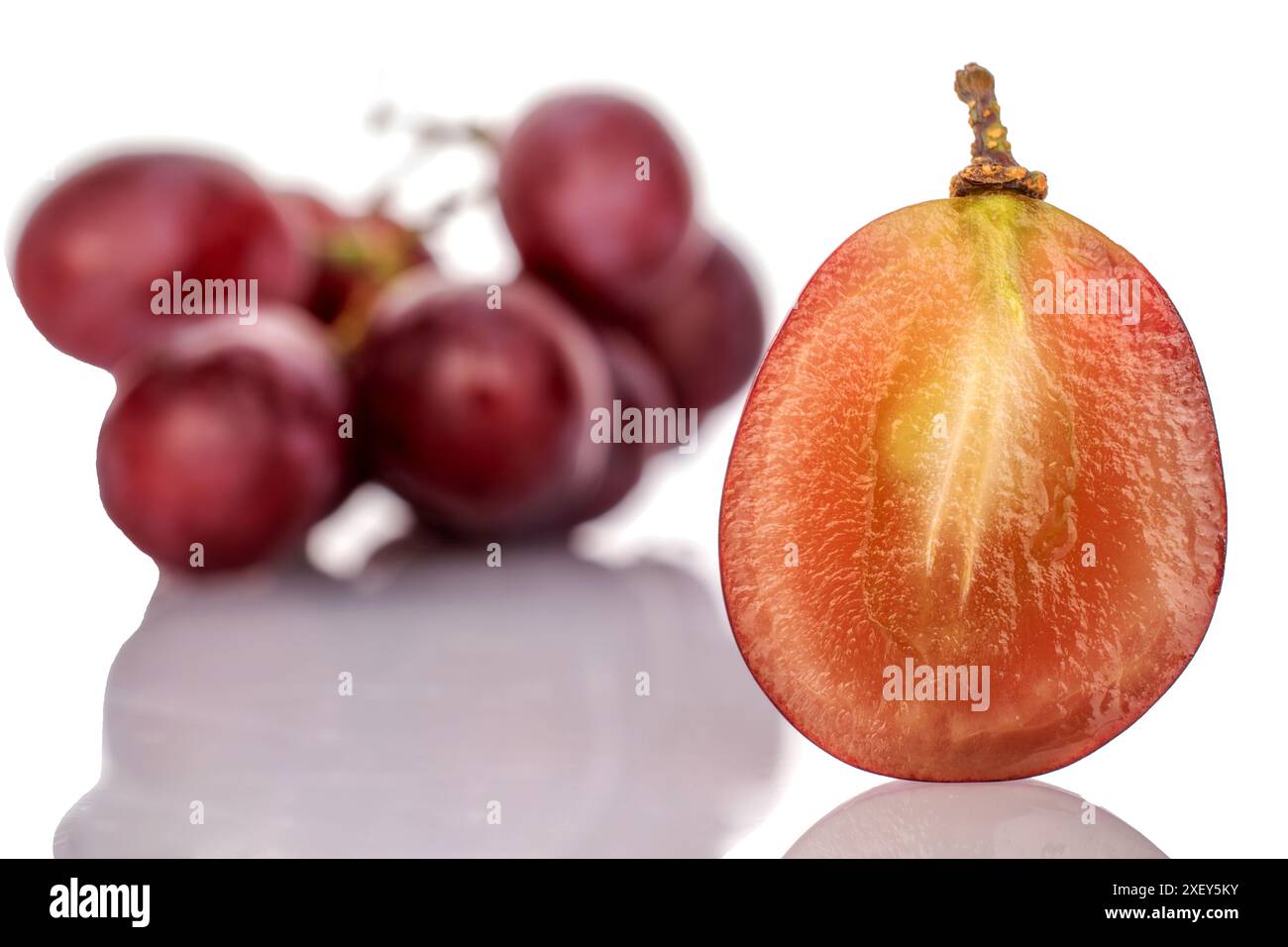One half of a berry and one bunch of grapes, macro, isolated on white ...