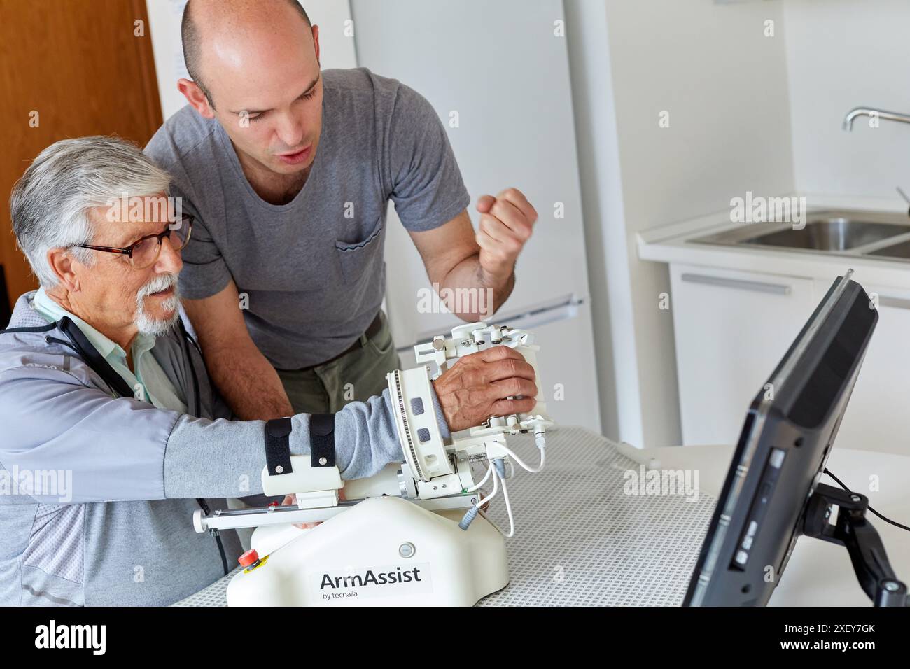 Patient with assistive robot for upper limb rehabilitation, The robot ...