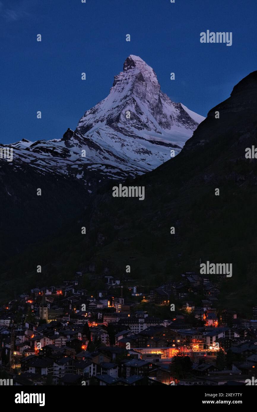 A stunning night view of the Matterhorn mountain with the town of ...