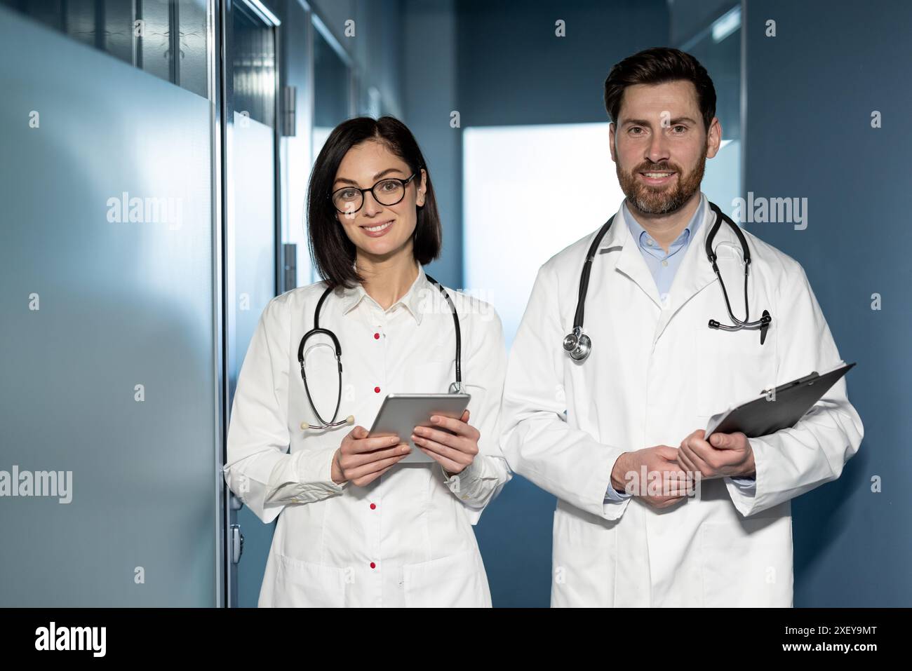 Healthcare professionals standing in hospital holding tablet and clipboard. Medical doctors ...