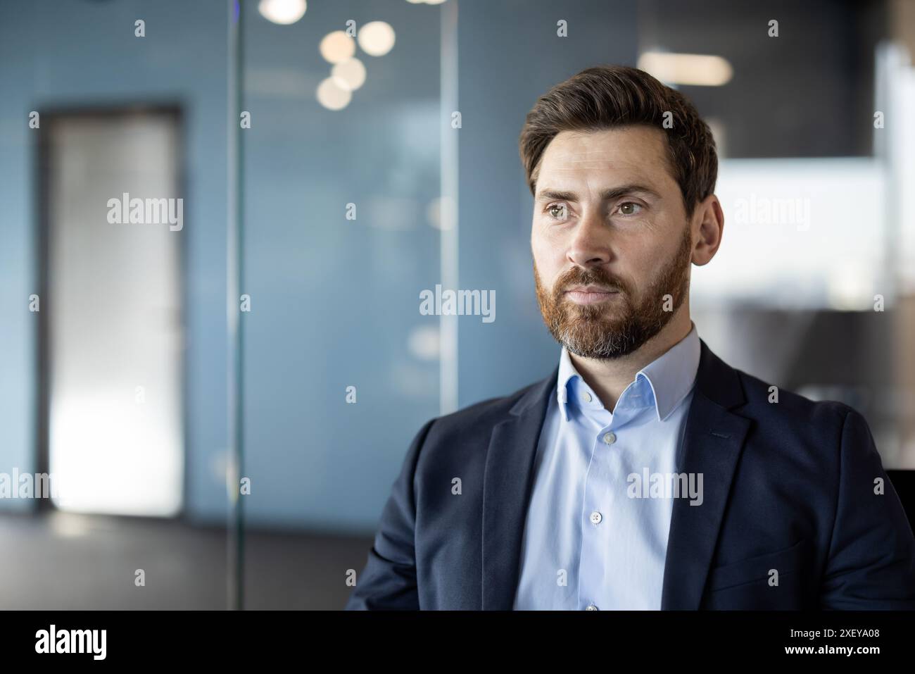 Business professional with beard and suit in modern office environment ...