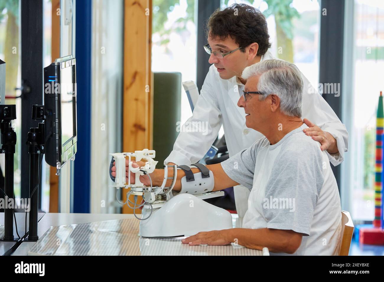 Therapist and patient with assistive robot for upper limb ...