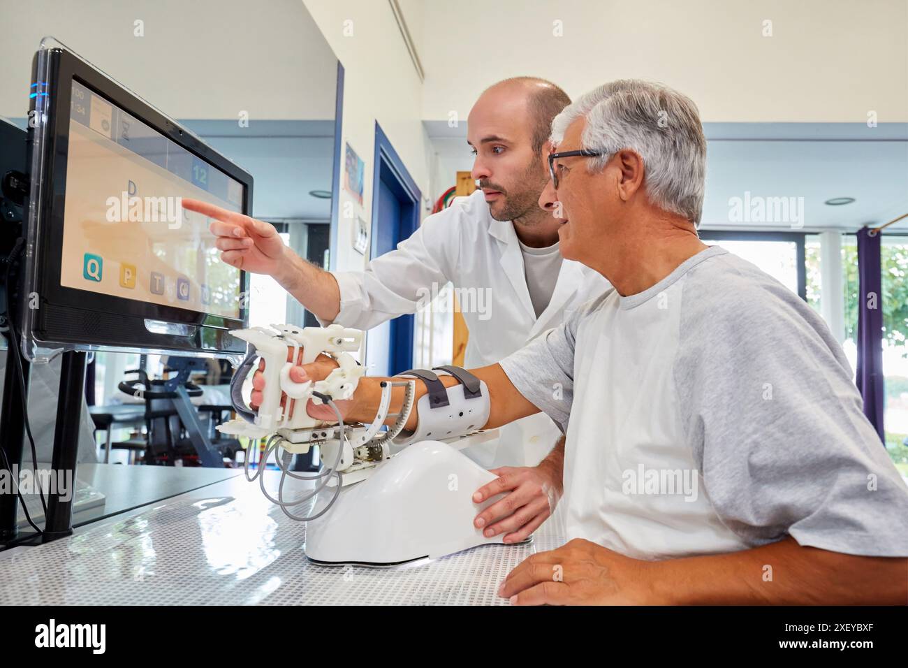 Therapist and patient with assistive robot for upper limb ...