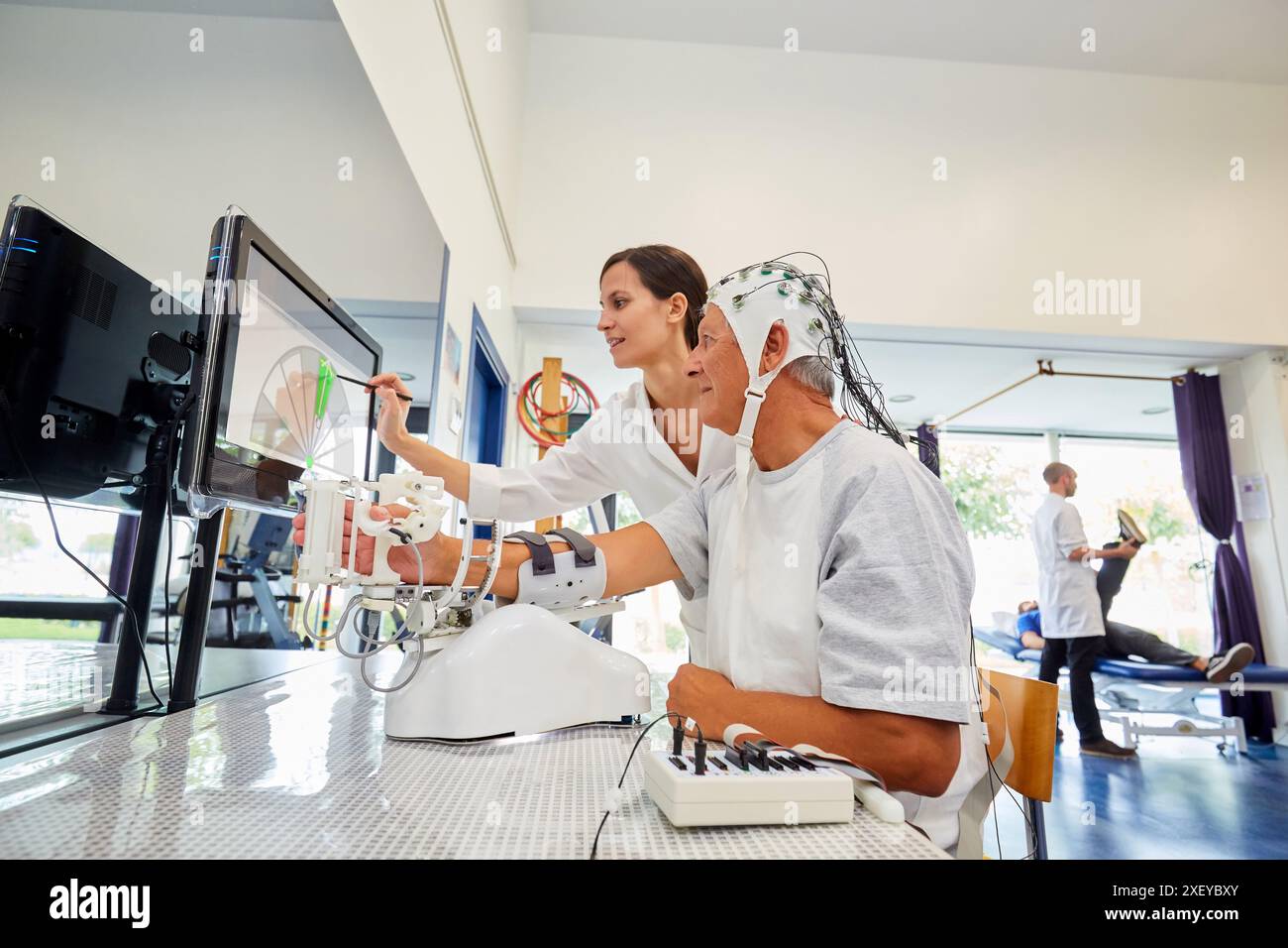 Investigator and patient with assistive robot for upper limb ...